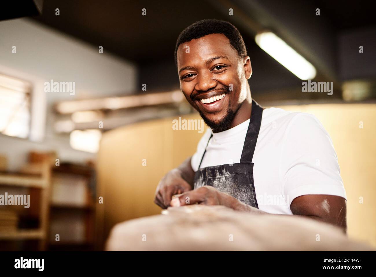 I have fun with what I do. a male baker removing freshly baked bread ...