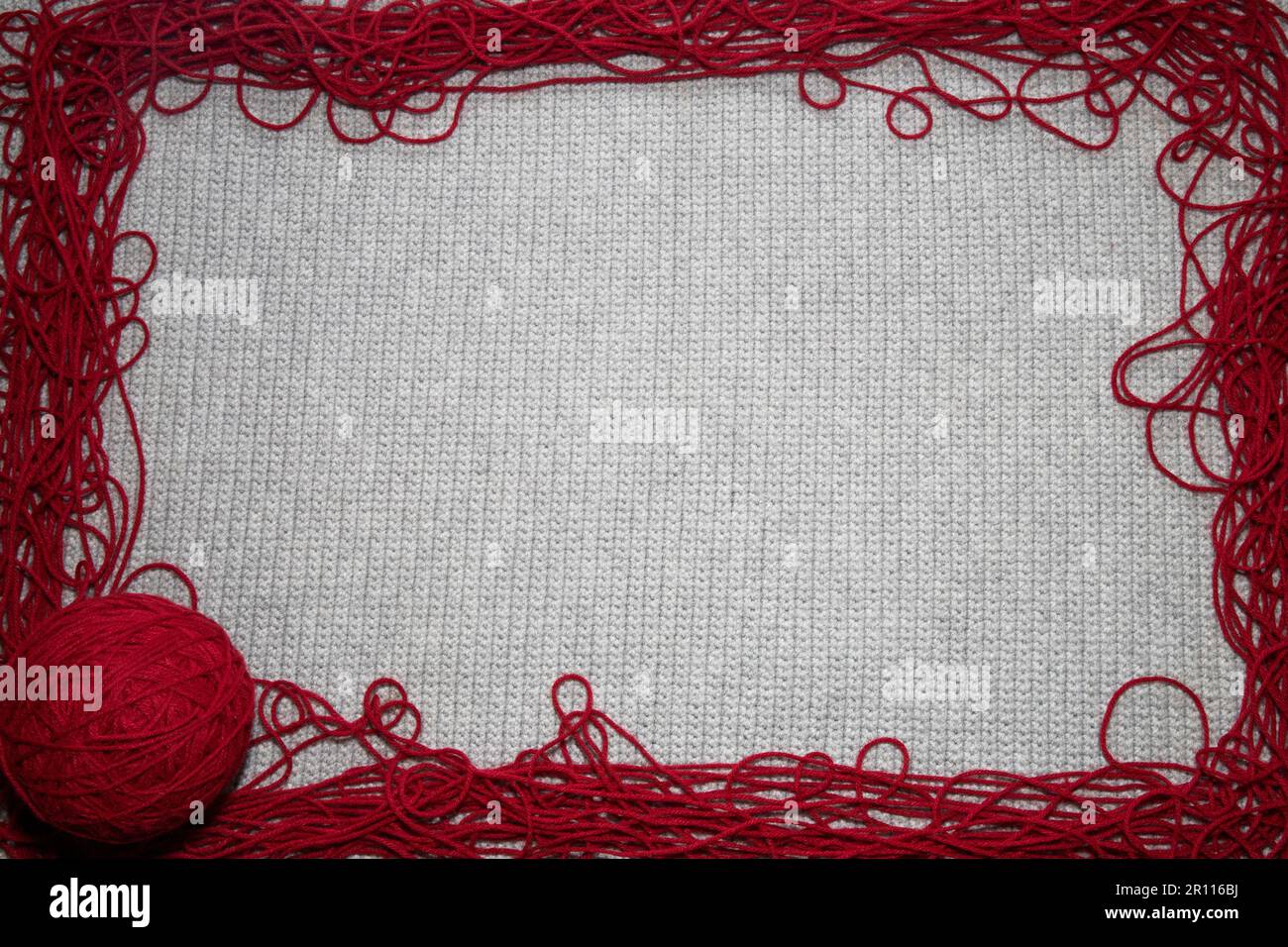 top view of crocheted gray background with red yarn border with a place ...