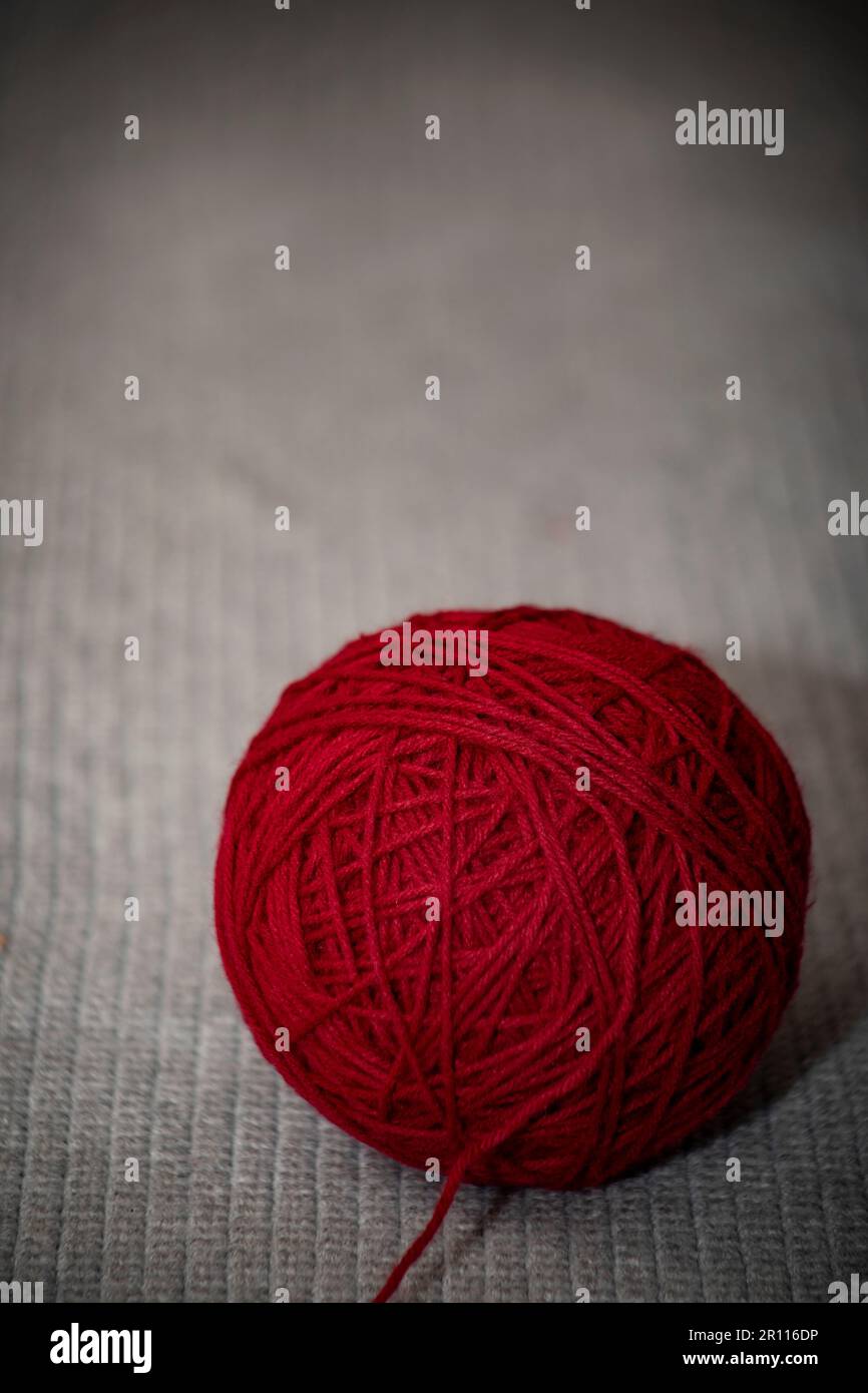 red ball of yarn on gray crocheted blanket with copy space, Craft hobby ...
