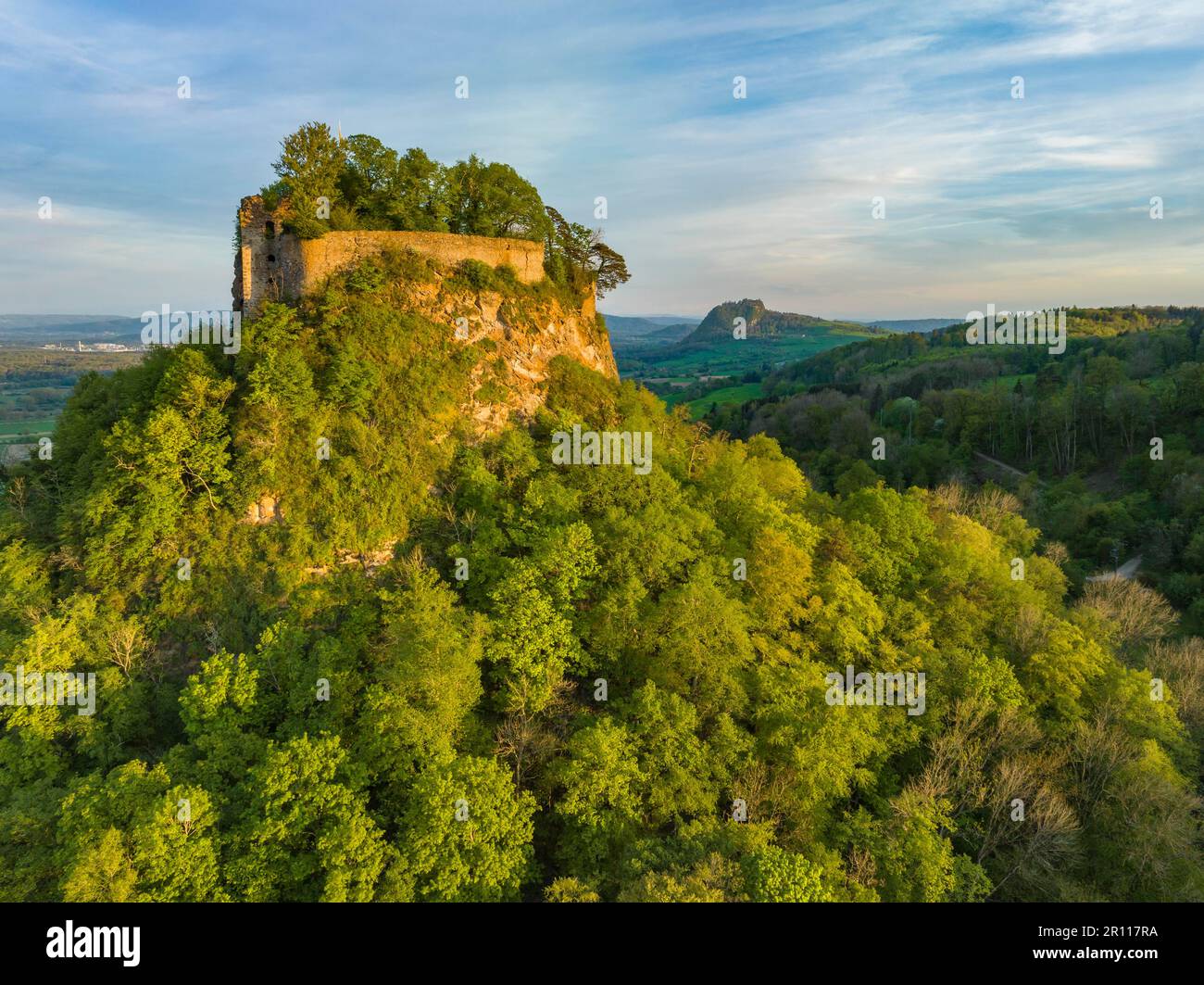 The Hegau volcano Hohenkraehen illuminated by the evening sun, behind ...