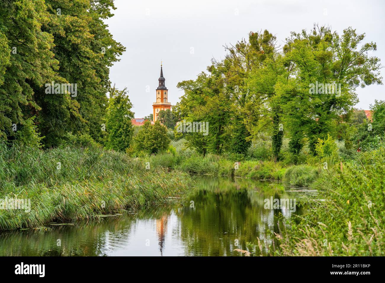 Green landscape along the Templin Canal, St. Mary Magdalene Church in ...