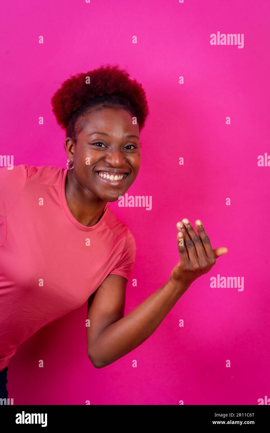 Young african american woman isolated on a pink background inviting to ...