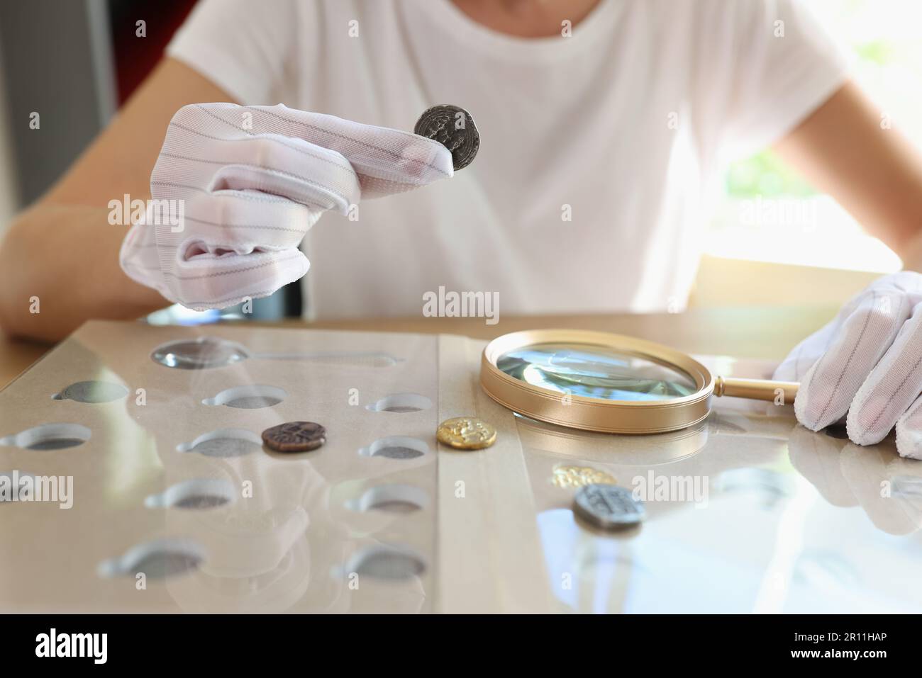 White gloves and coin and magnifier hi-res stock photography and images ...