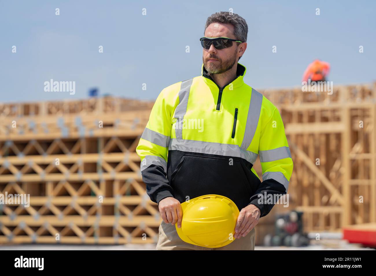 Worker near american wood frame house construction. American wooden ...