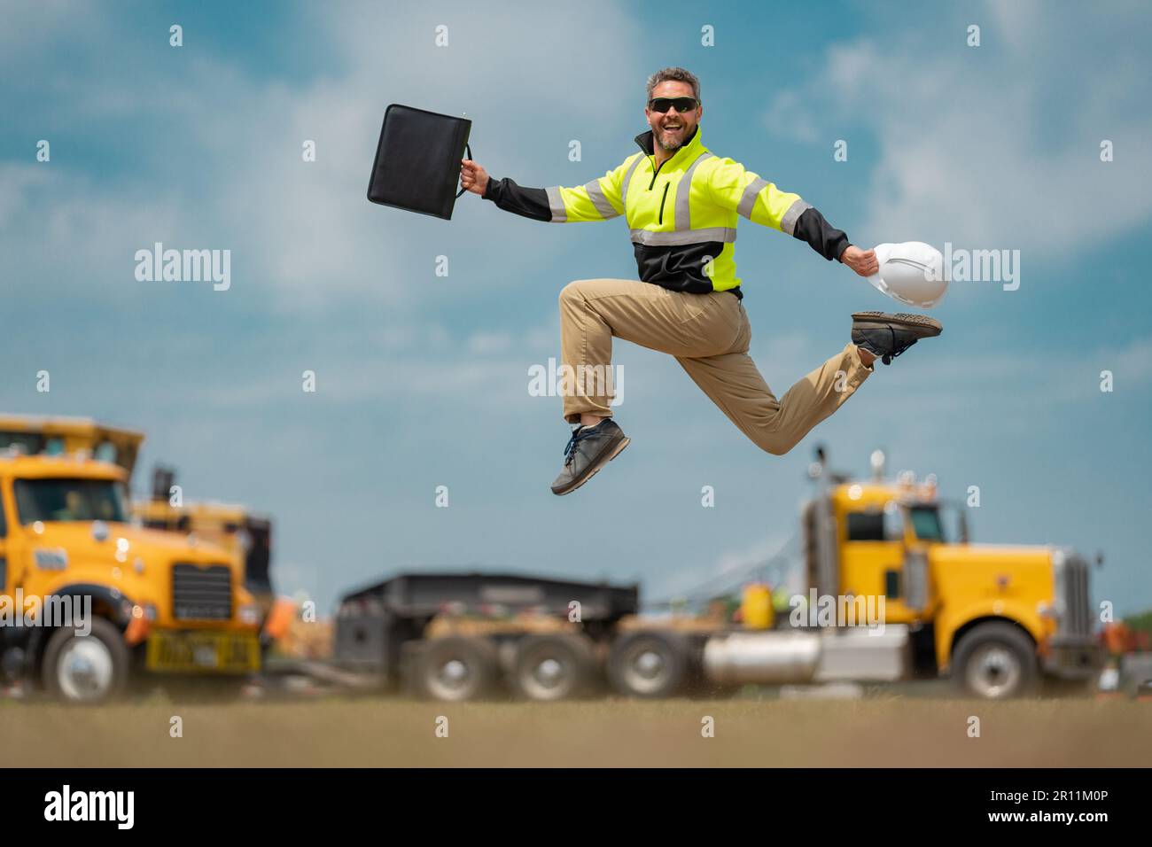 Middle aged builder excited jump on site construction. Excited builder ...