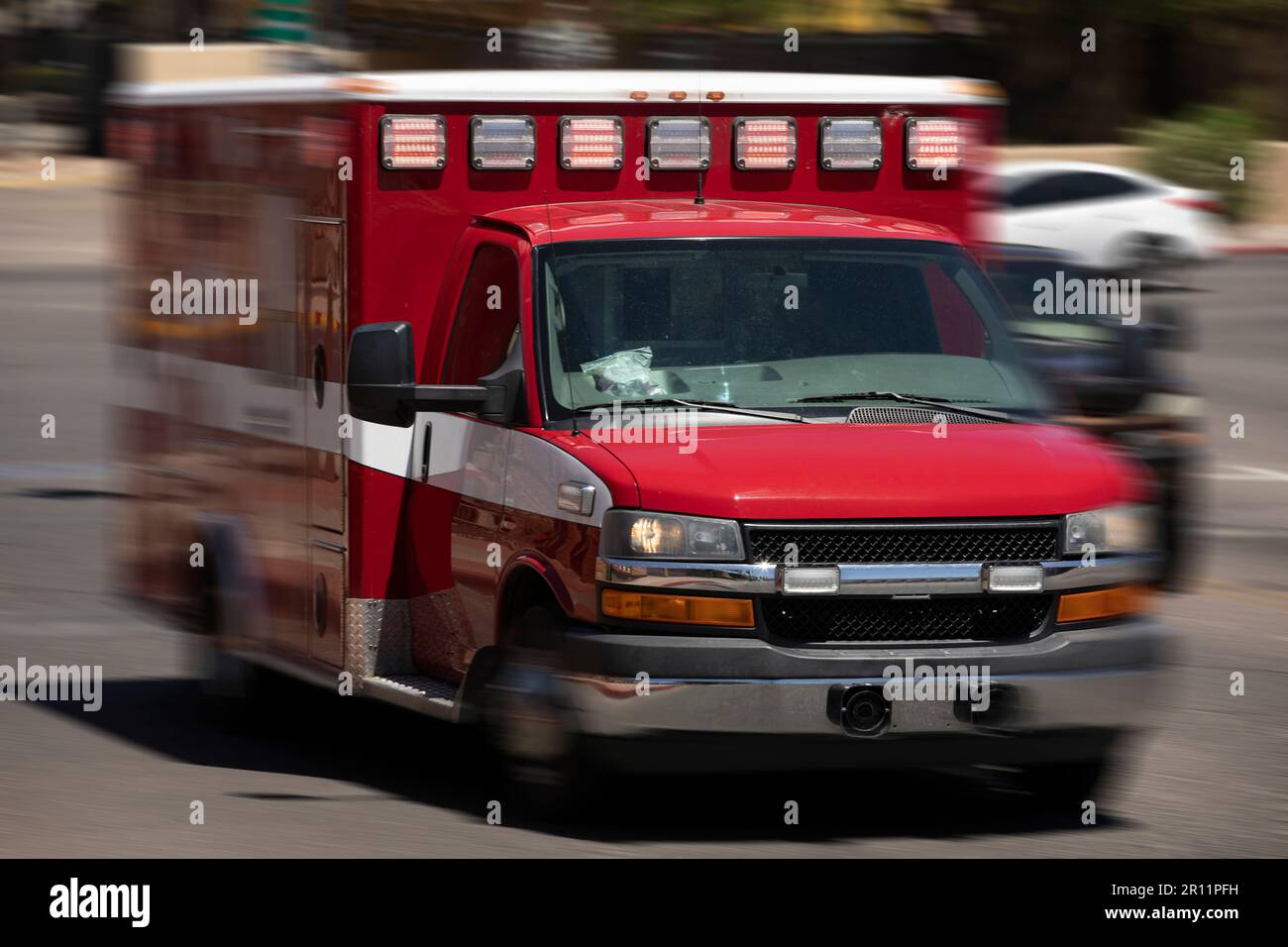 Daytime motion blurred view of an ambulance racing to the scene of an ...