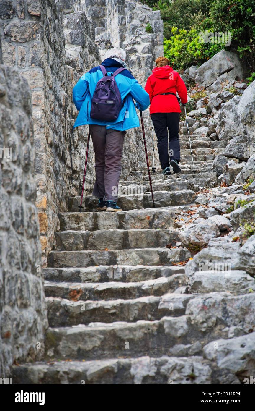 Rear view of senior couple climbing stairs on city walls in Ston ...