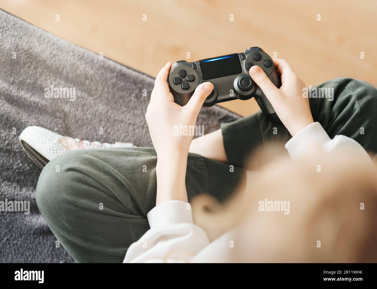 A little girl holding game controller playing video games Stock Photo ...