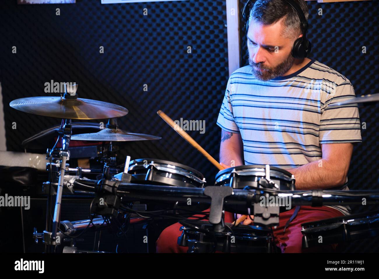 Man playing drums with headphones in a recording studio Stock Photo - Alamy