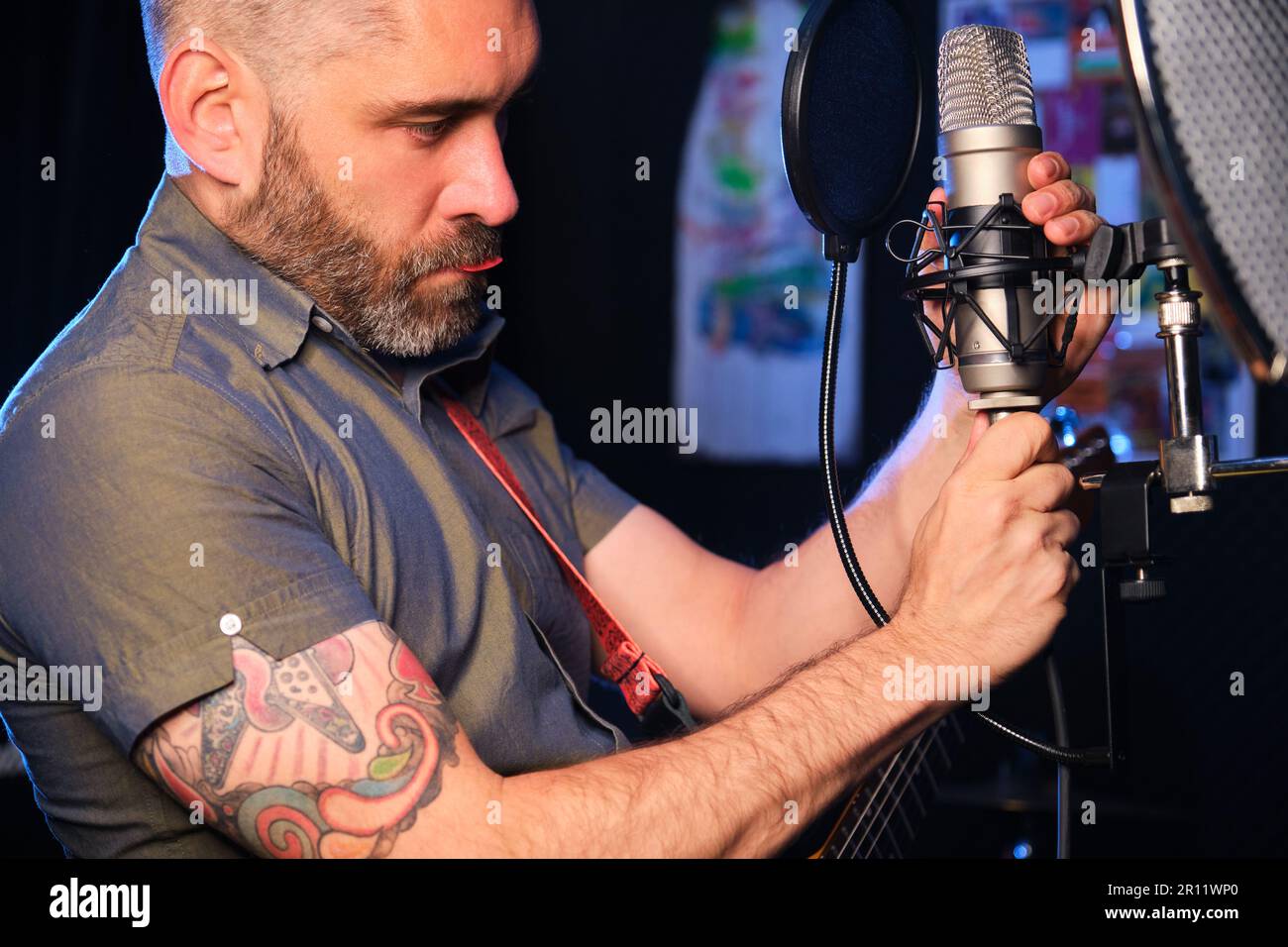 Singer and guitarist adjusting the microphone before recording at ...