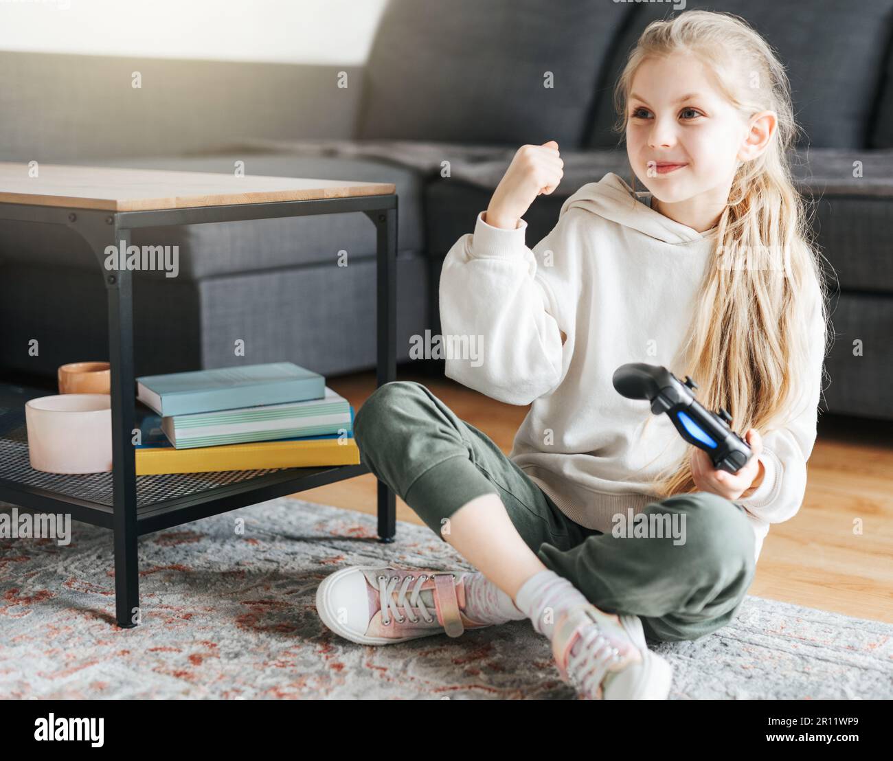 A little girl holding game controller playing video games Stock Photo ...