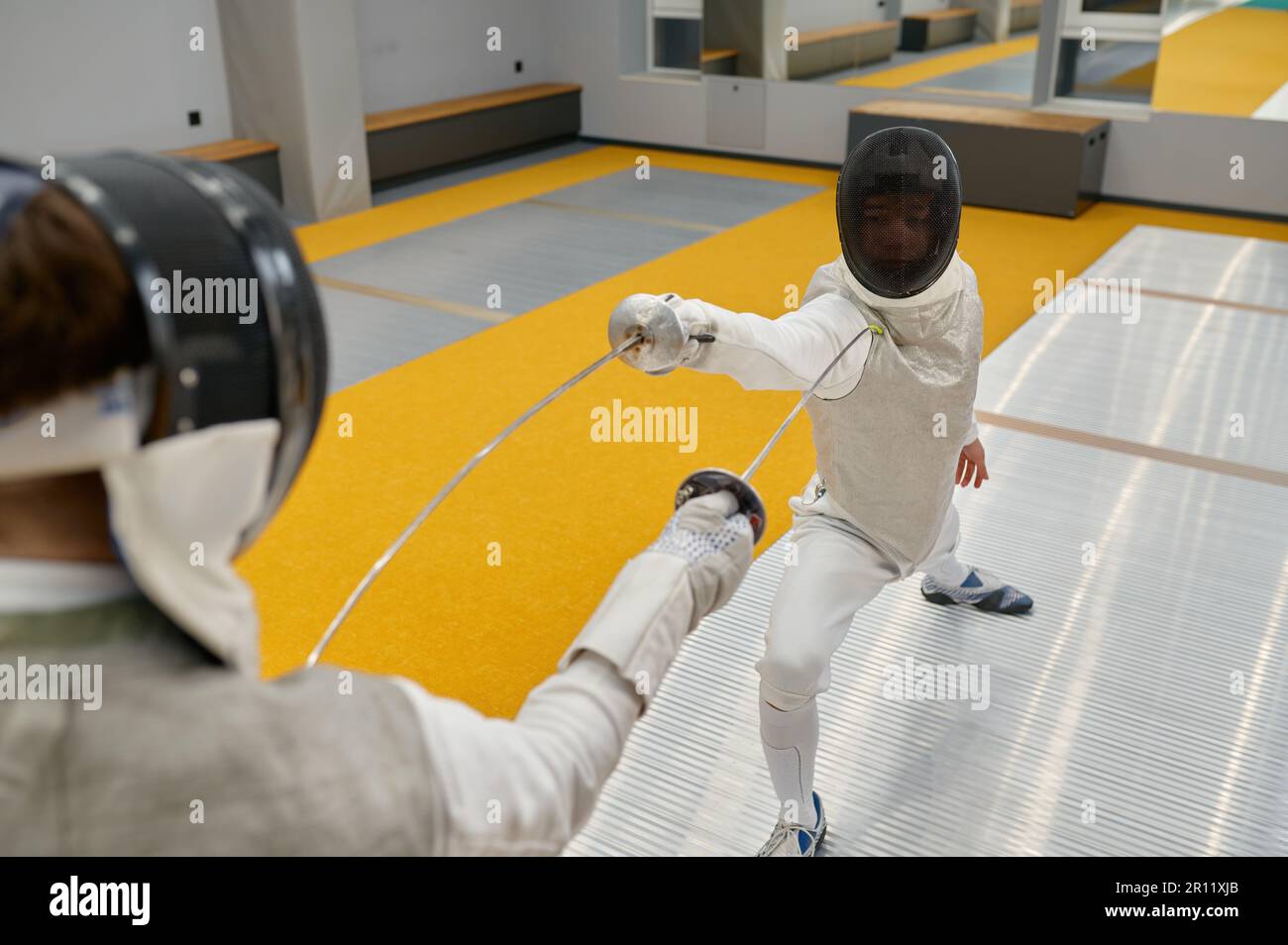 Two young swordsmen in uniform practicing attack and defense during ...