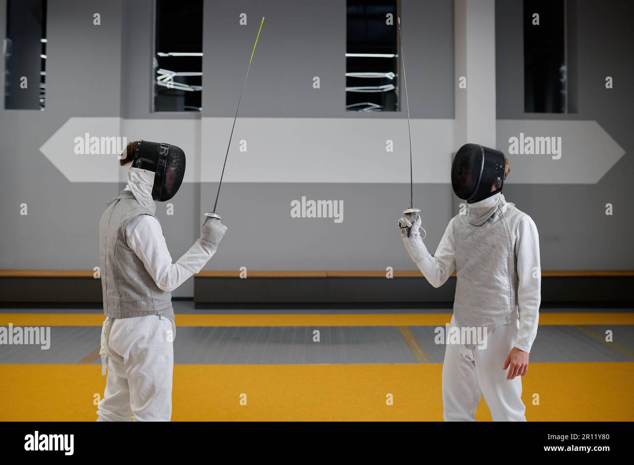 Two fencers staying with raised rapiers front of each other ready to ...