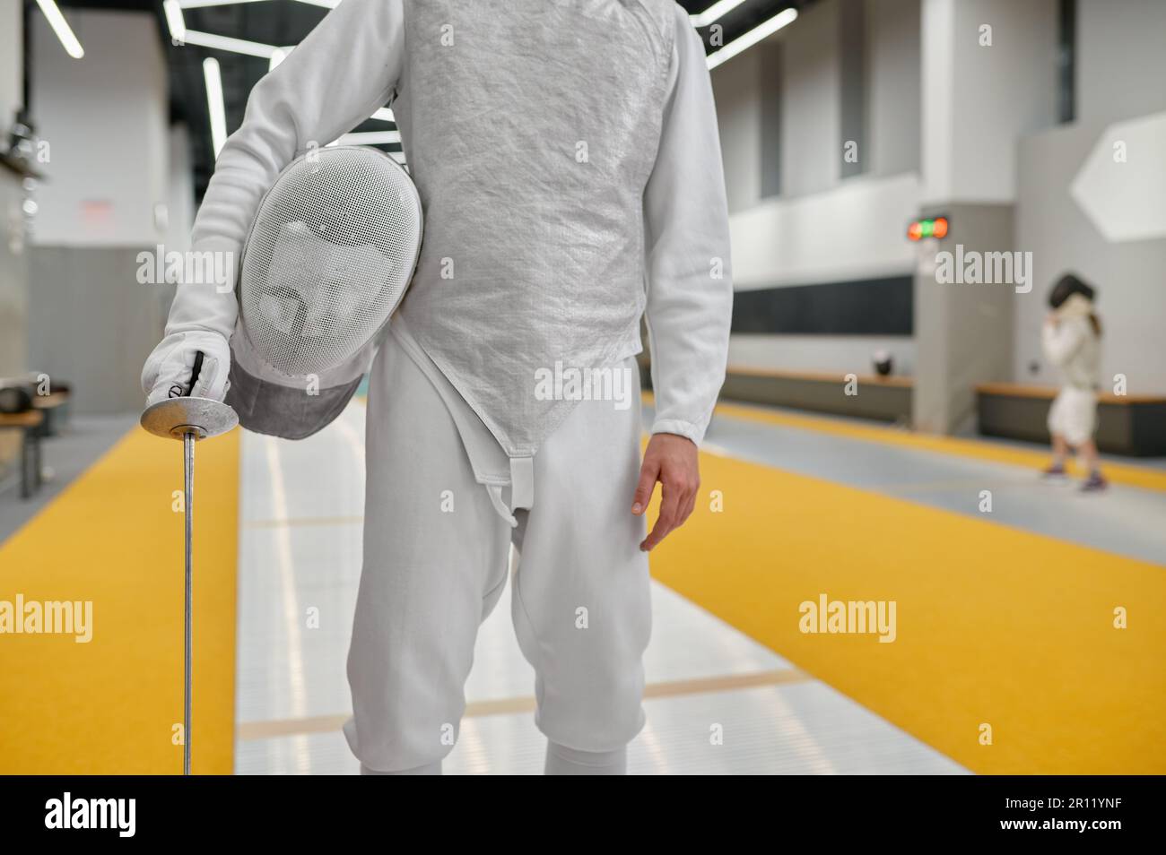 Crop view of fencer standing over gym interior Stock Photo - Alamy