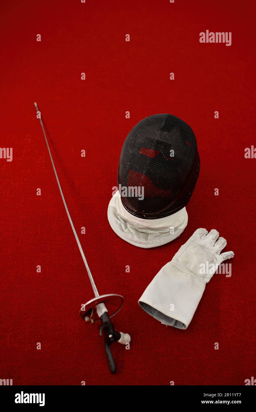 Fencing equipment concept, crossed swords and protective helmet with ...