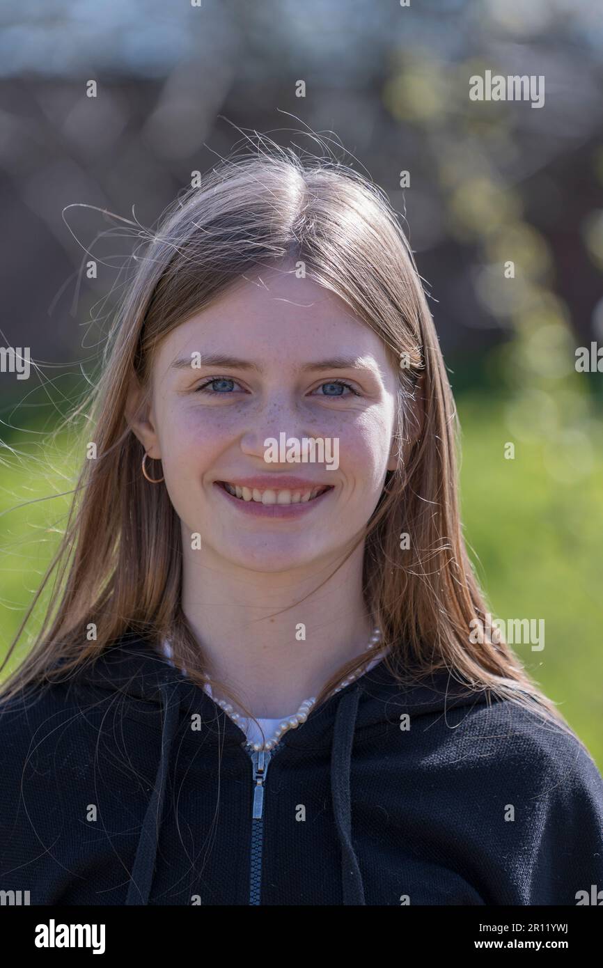 Portrait of a beautiful happy girl with blond hair and freckles looking ...