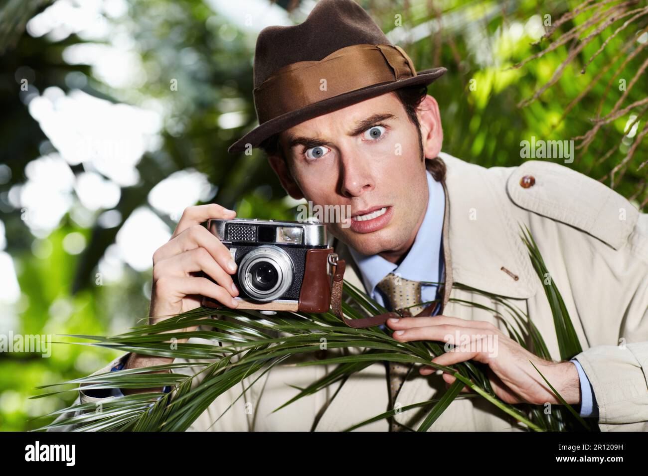 Retro spy man, camera and jungle for investigation, inspection or ...