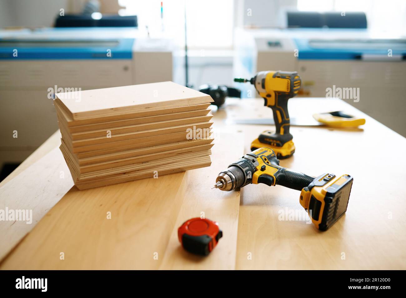 Electric drill, ruler and wooden board at carpenter workplace Stock ...
