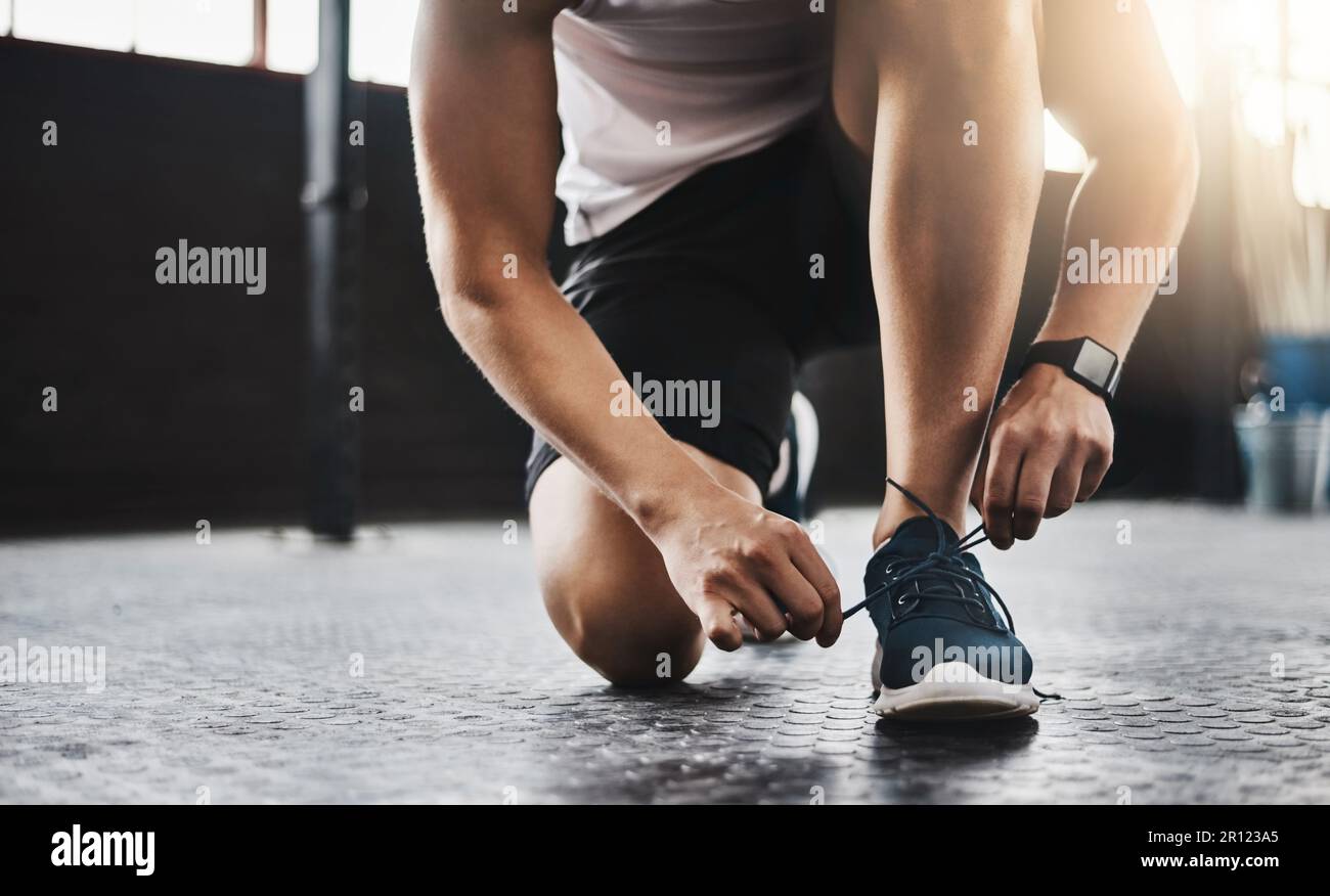 Put your best foot forward in the fitness game. a man tying his ...