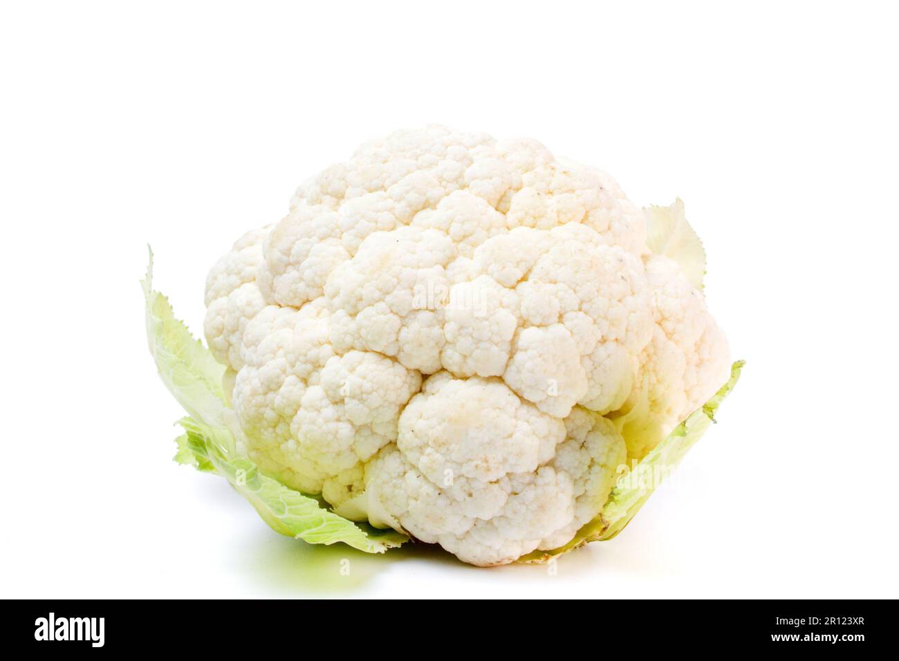 Whole head of fresh white raw cauliflower with leaves close-up on white ...