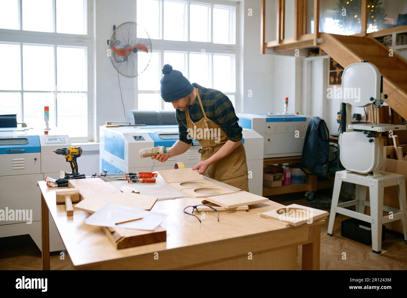 Portrait of experienced man carpentry worker applying glue on board ...