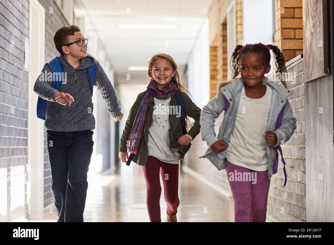 Racing to class. elementary school kids running in the corridor at ...