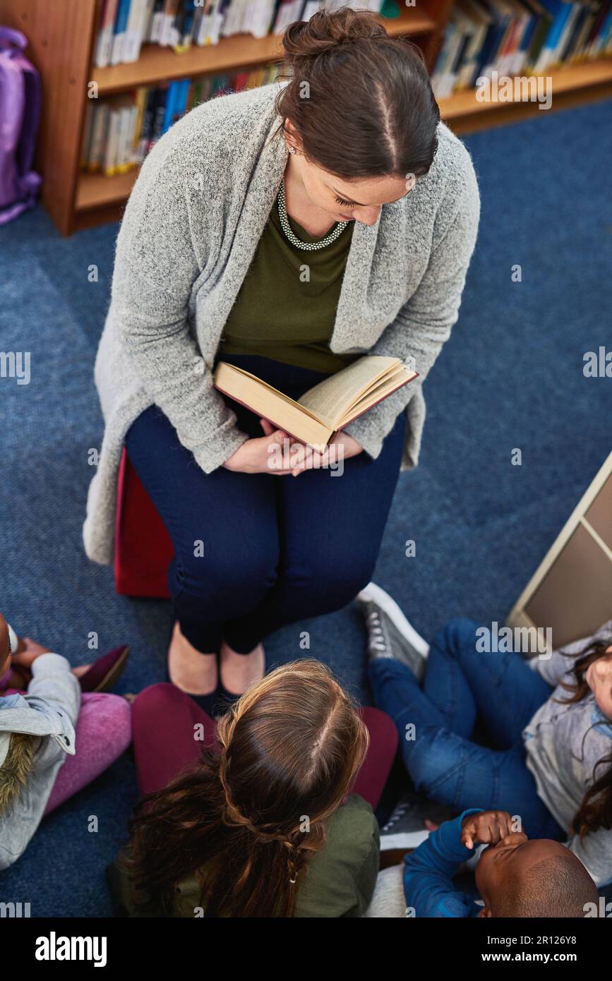 Encouraging their curious minds. a teacher reading to a group of ...