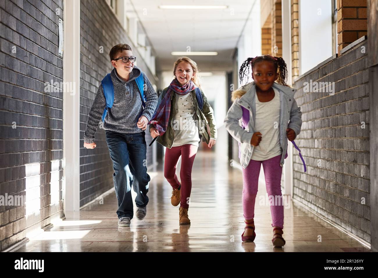 Who will get to class first. elementary school kids running in the ...