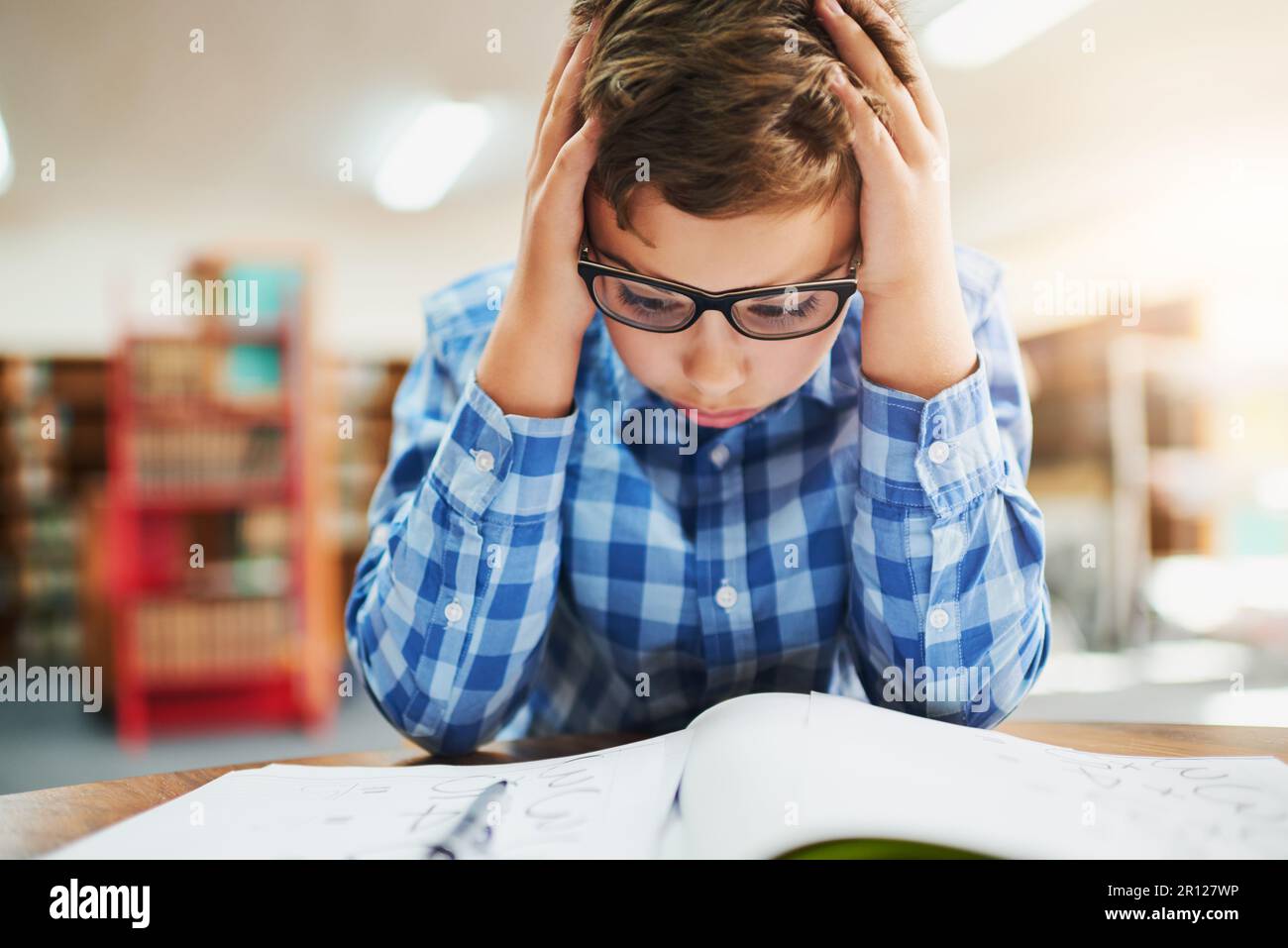 This one is difficult. a young boy looking stressed out while working ...