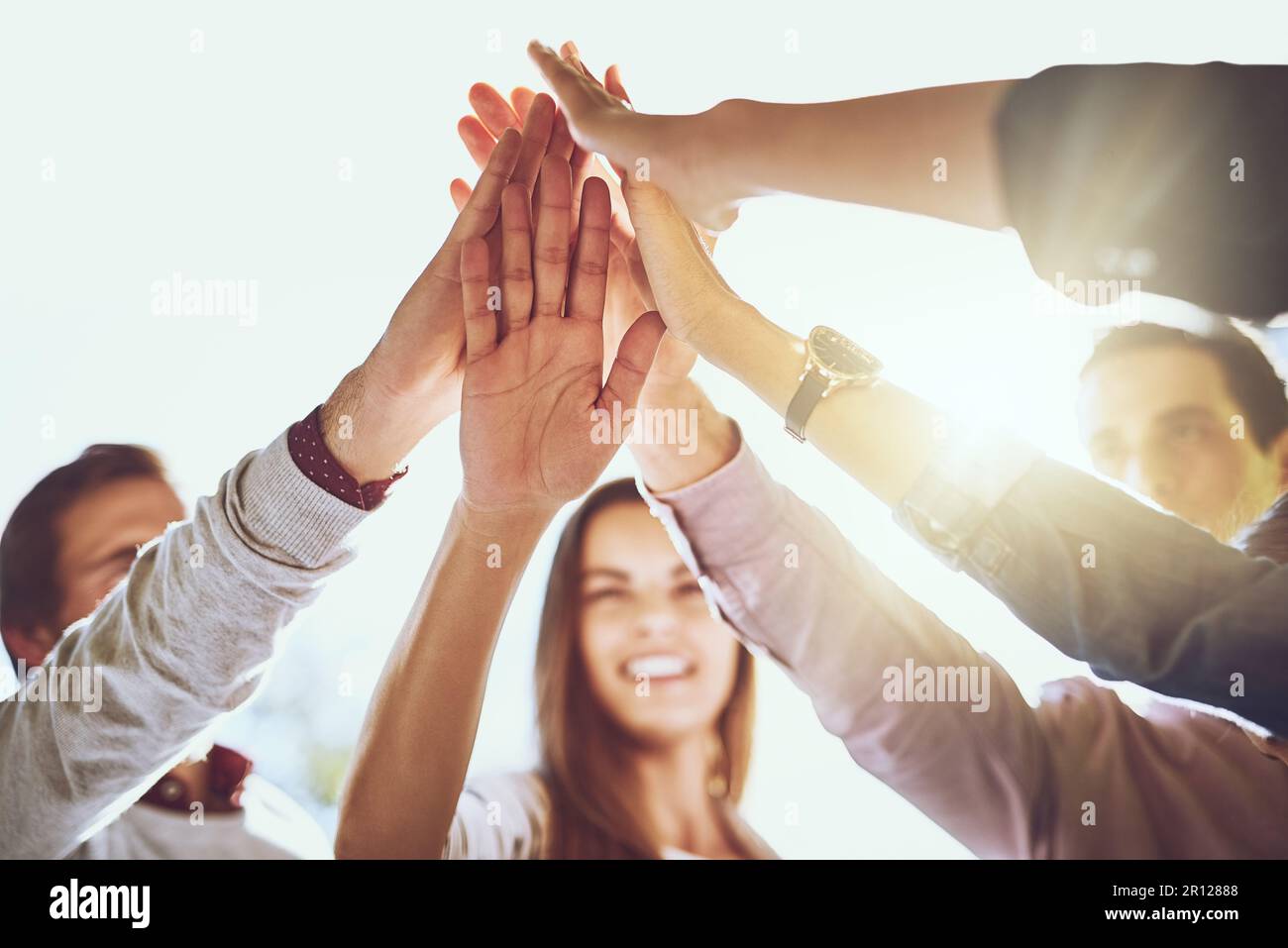 We rise when we lift each other up. a group of colleagues joining hands ...