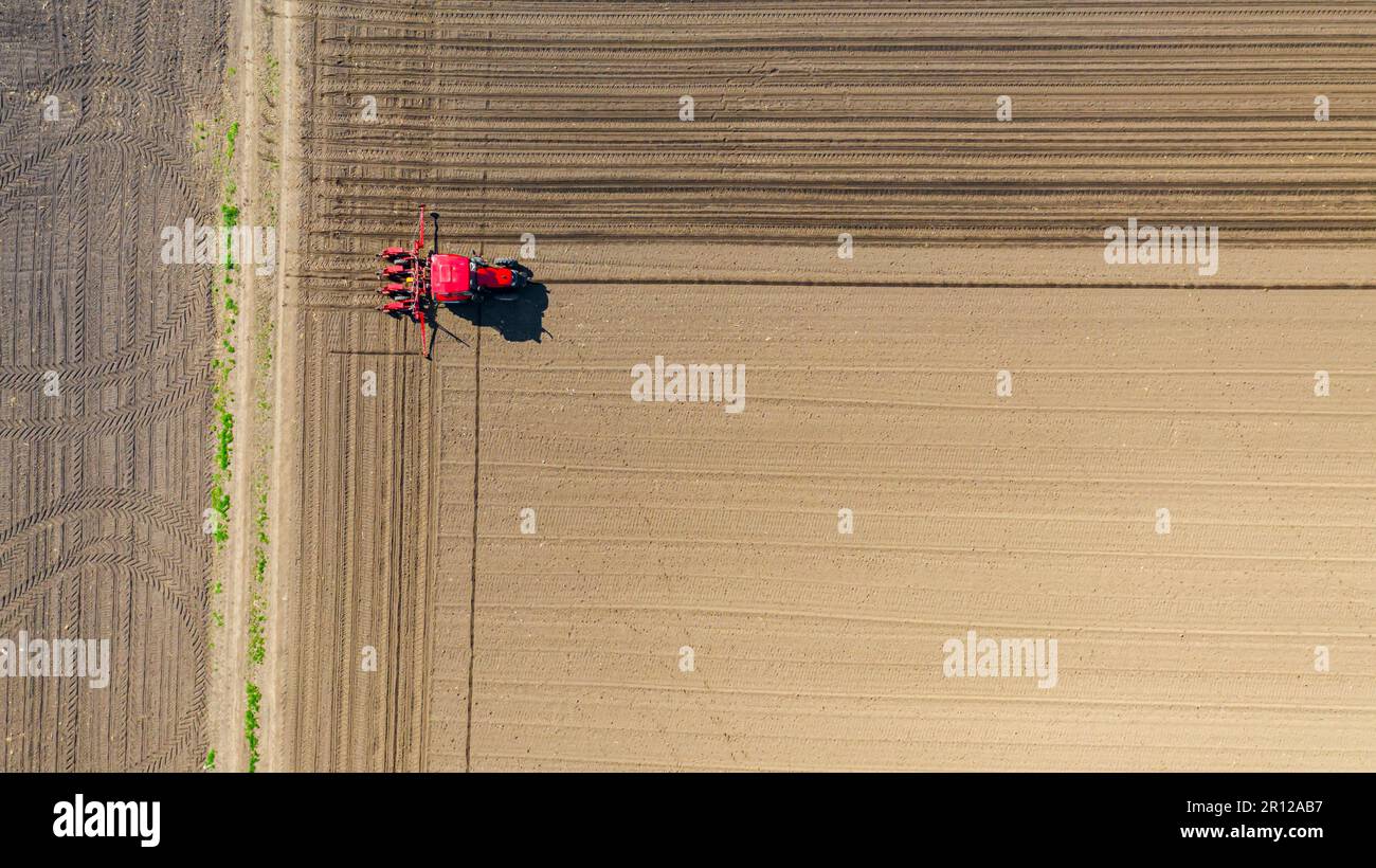Above top view, of tractor as pulling mechanical seeder machine over ...