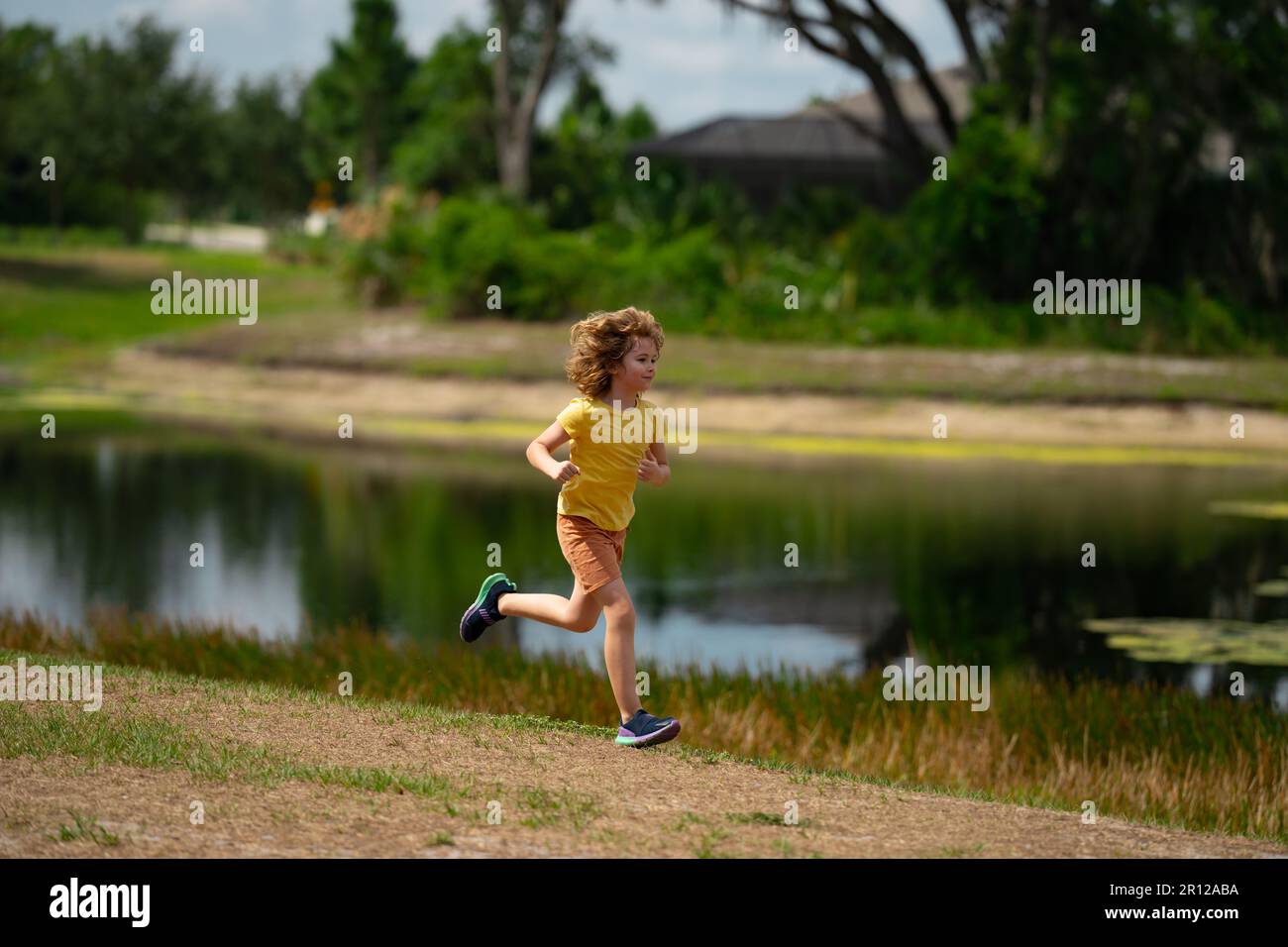 Cute kid boy running across american neighborhood street. Summer ...