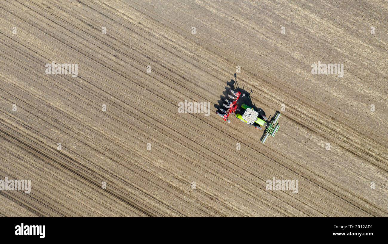 Above top view, of tractor as pulling mechanical seeder machine over ...