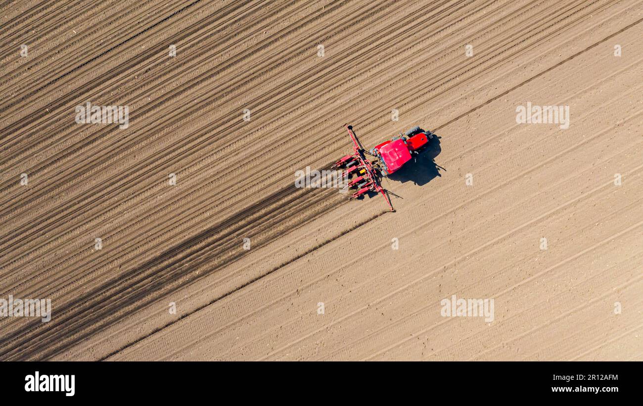 Above top view, of tractor as pulling mechanical seeder machine over ...