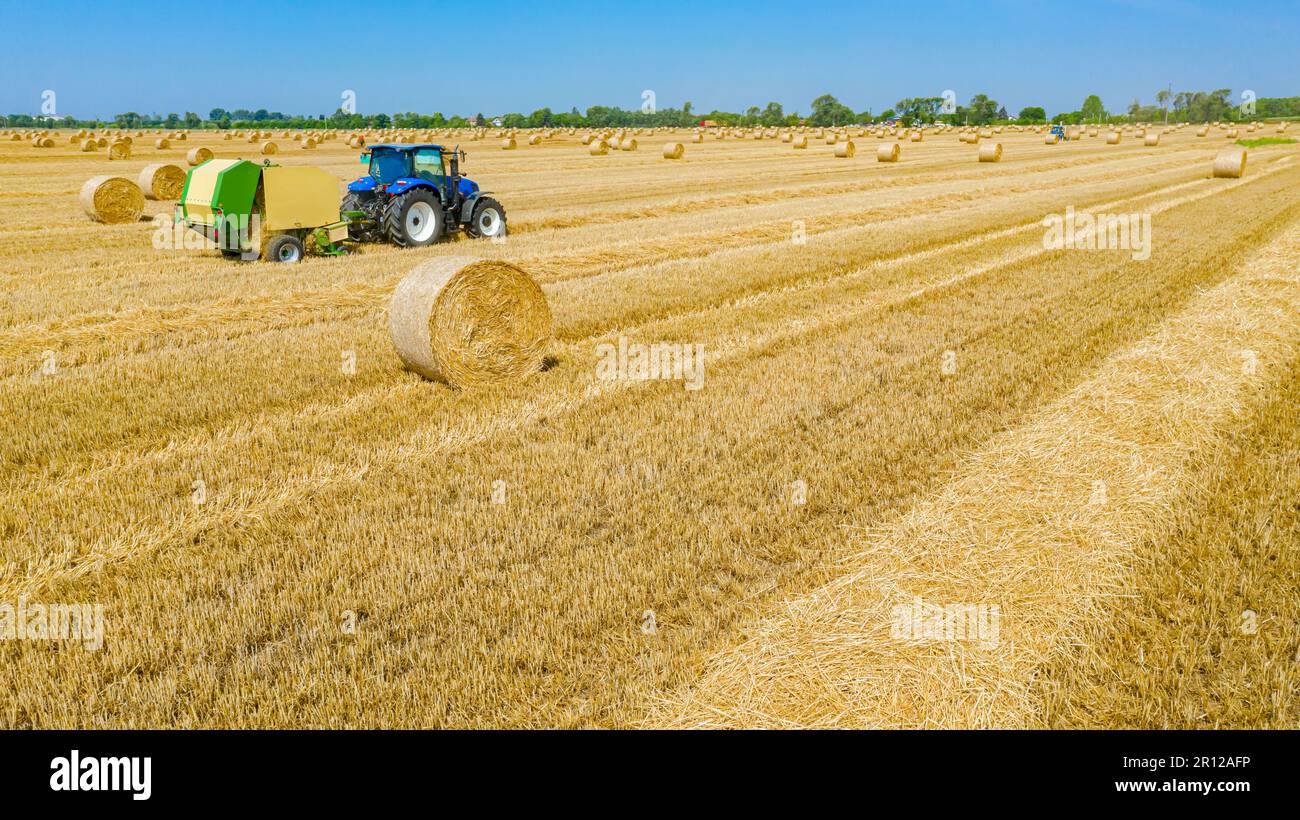 Above view on tractor as pulling round baler, machine that rolls up the ...