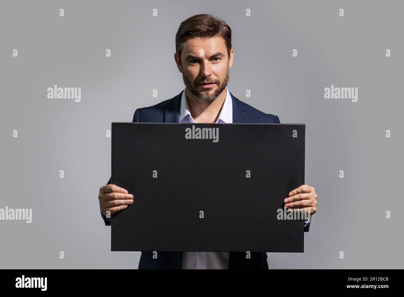 Serious business man holding empty board. Successful businessman ...