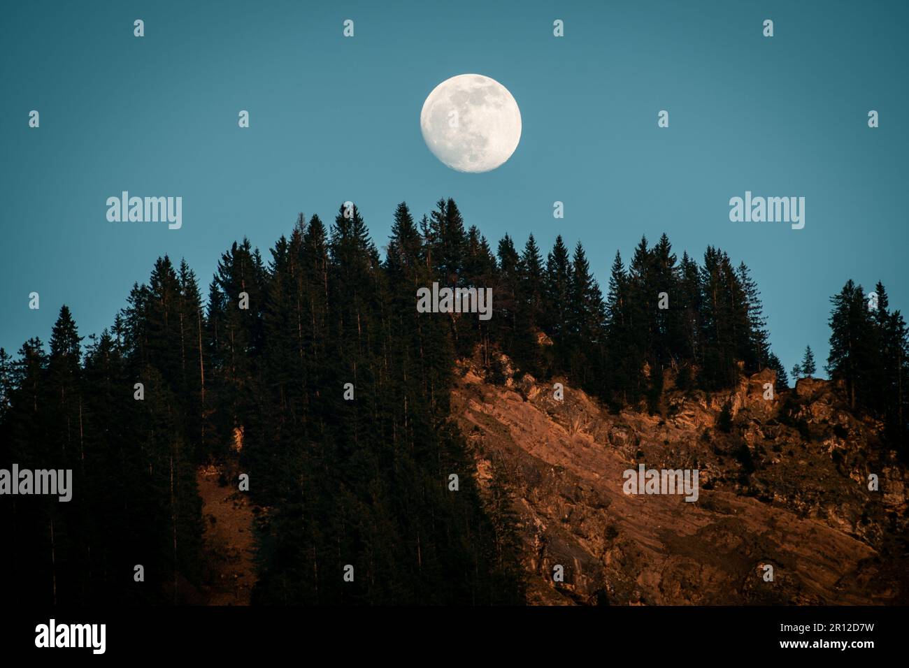 An almost full moon rising above the Swiss Alps Stock Photo - Alamy