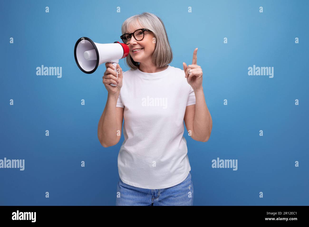 portrait of an old woman grandmother speaker with gray hair holding a ...