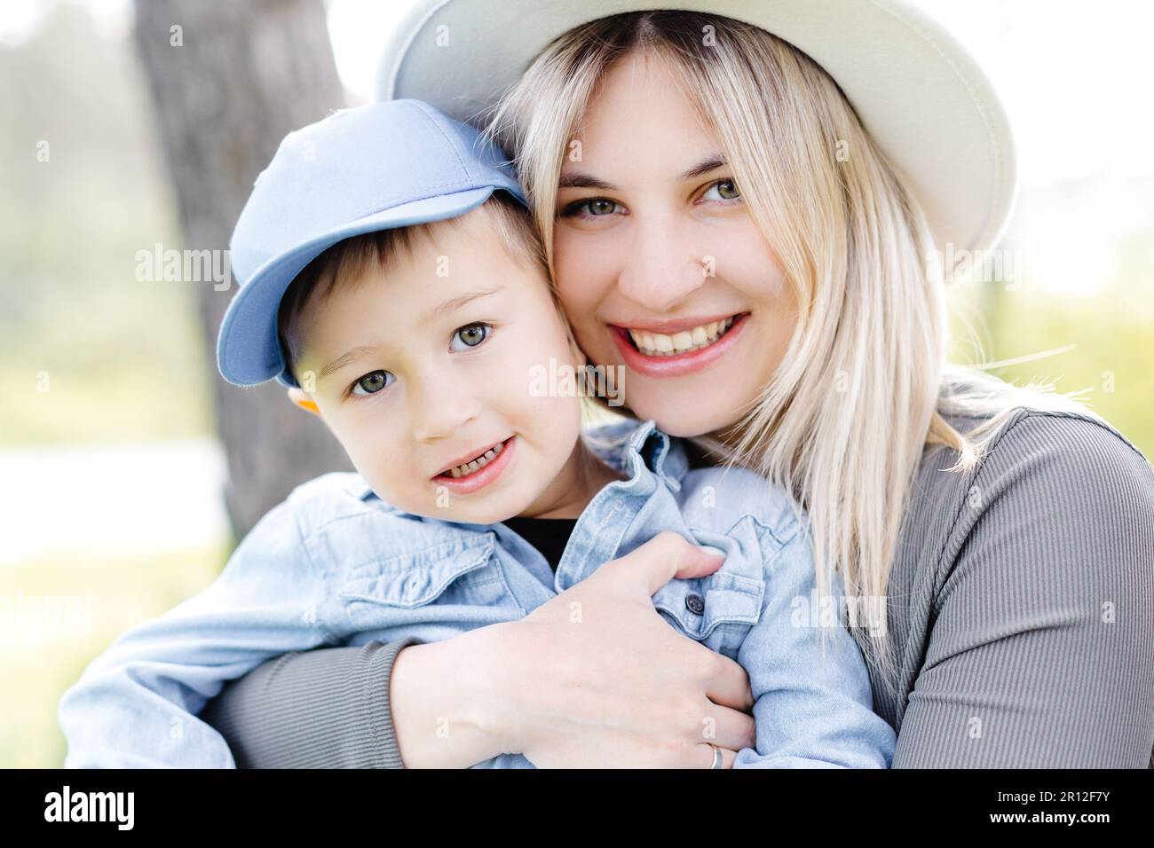 Pregnant mother and her little son walking and hugging in the forest and funny spending time ...
