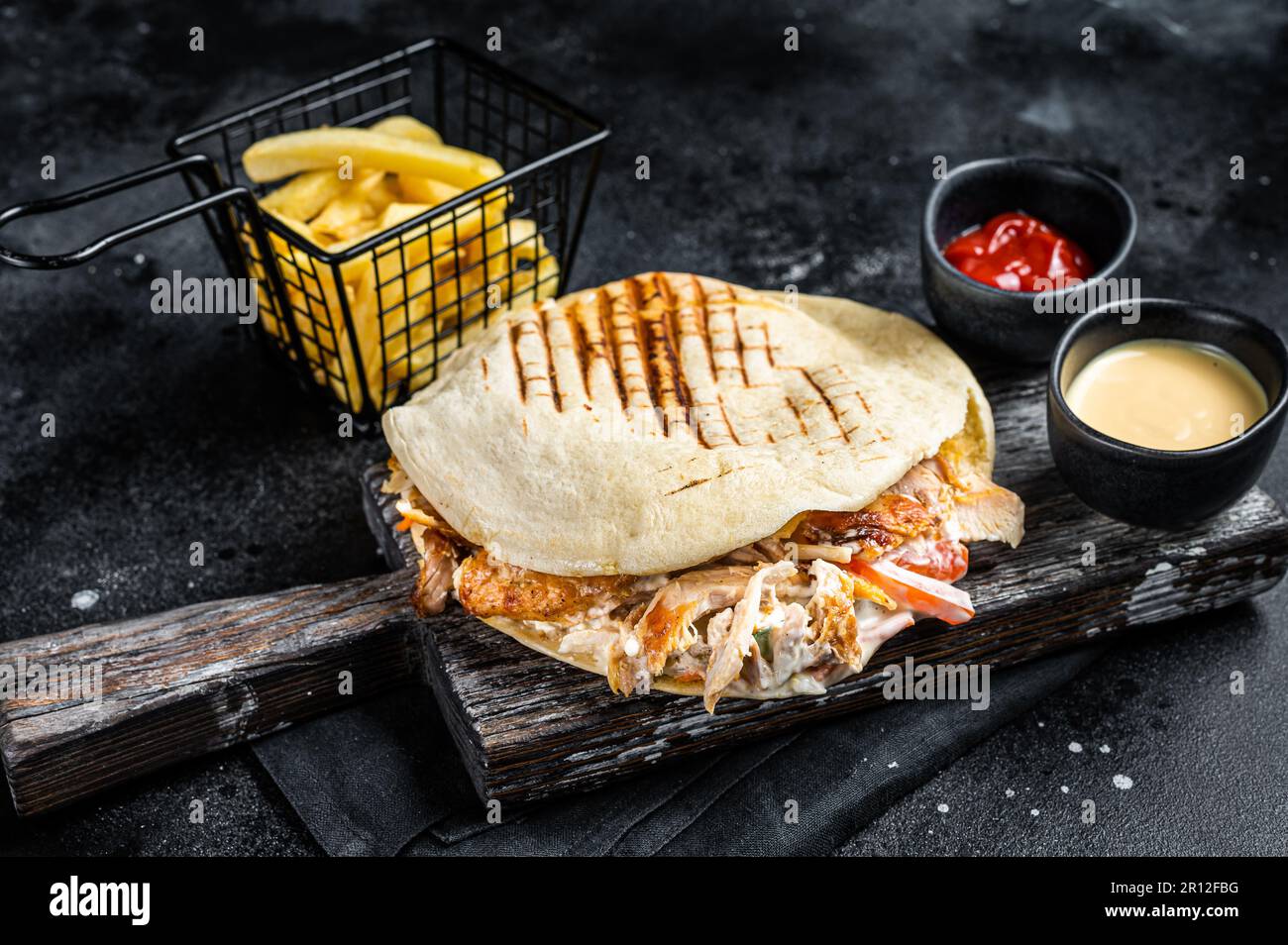 Turkish doner kebab in grilled pita bread with chicken meat. Black ...