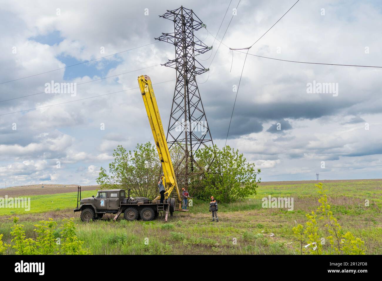 Workers fixing electric power transmission line destroyed during ...