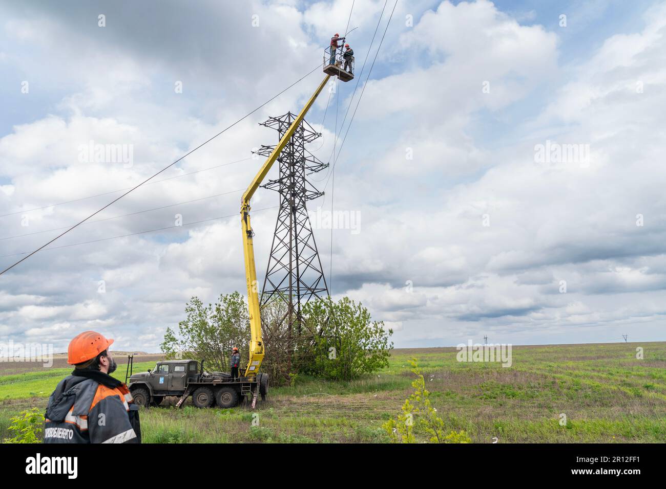 Workers fixing electric power transmission line destroyed during ...