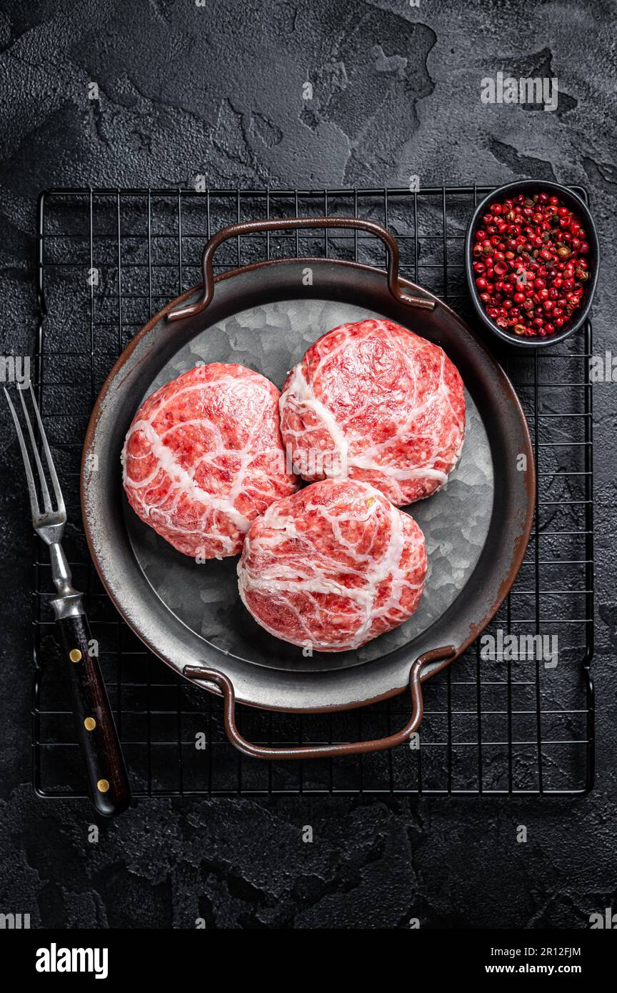 Raw pork cutlet, Crepinette with spices and herbs. Black background ...