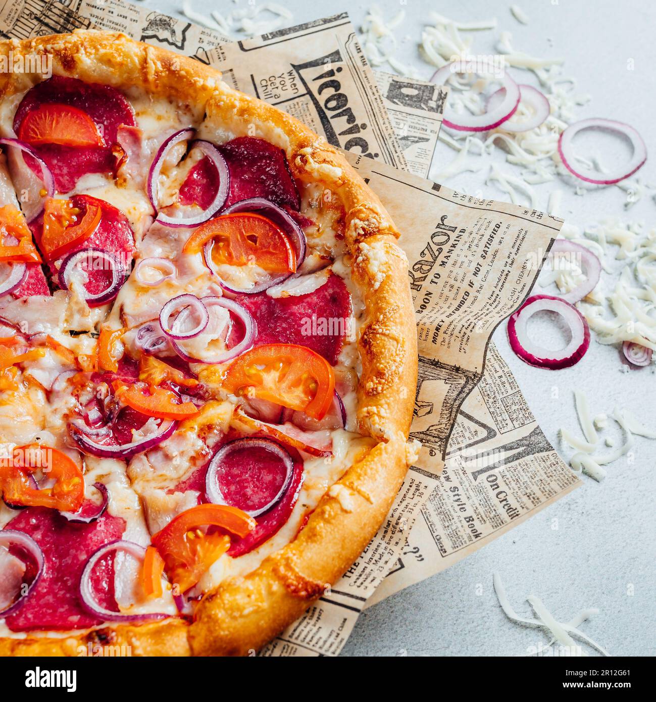A large round thin-crust pizza sitting on top of a crumpled newspaper ...