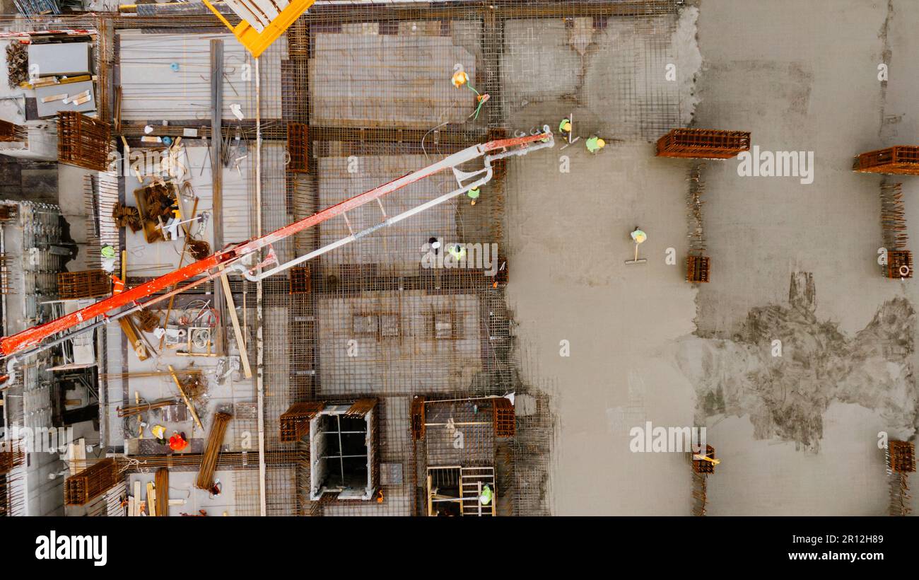 Aerial view of a construction site with workers pouring and leveling ...