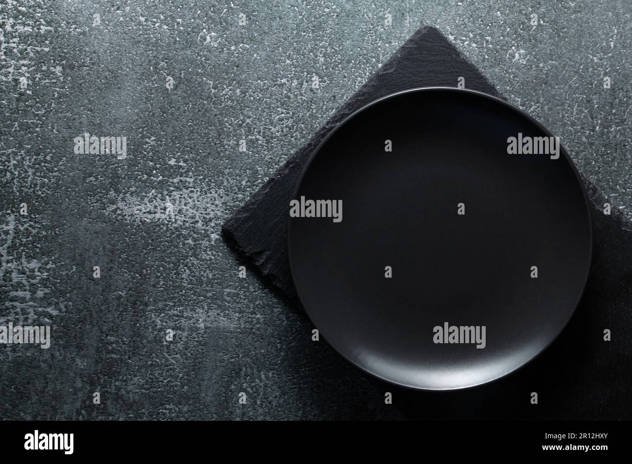 Dark empty plate without food on dark stone background, flat lay, top ...