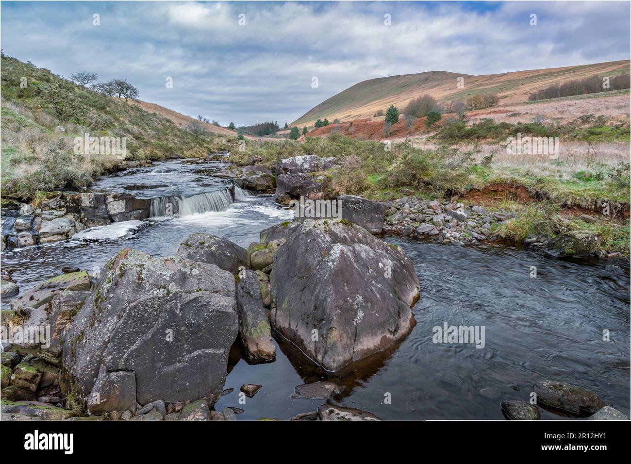 A scenic view of a rocky river, with the tranquil water flowing through ...