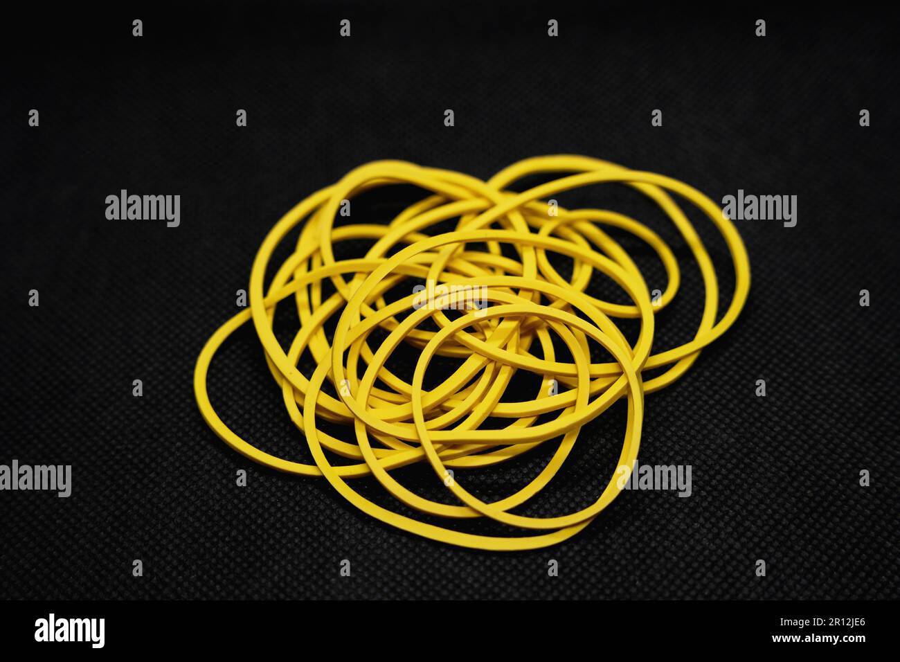 A close up of yellow rubber bands isolated on a black background Stock ...
