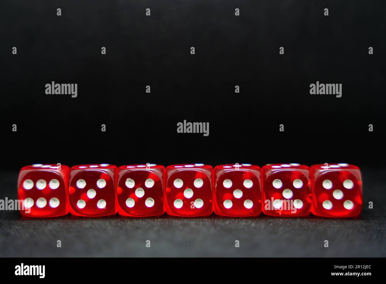 A close up of a line of red dice isolated on a black background Stock ...
