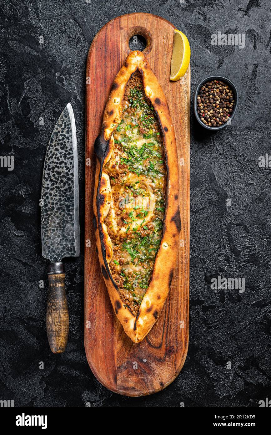 Turkish pide pie with beef meat and vegetables. Black background. Top ...